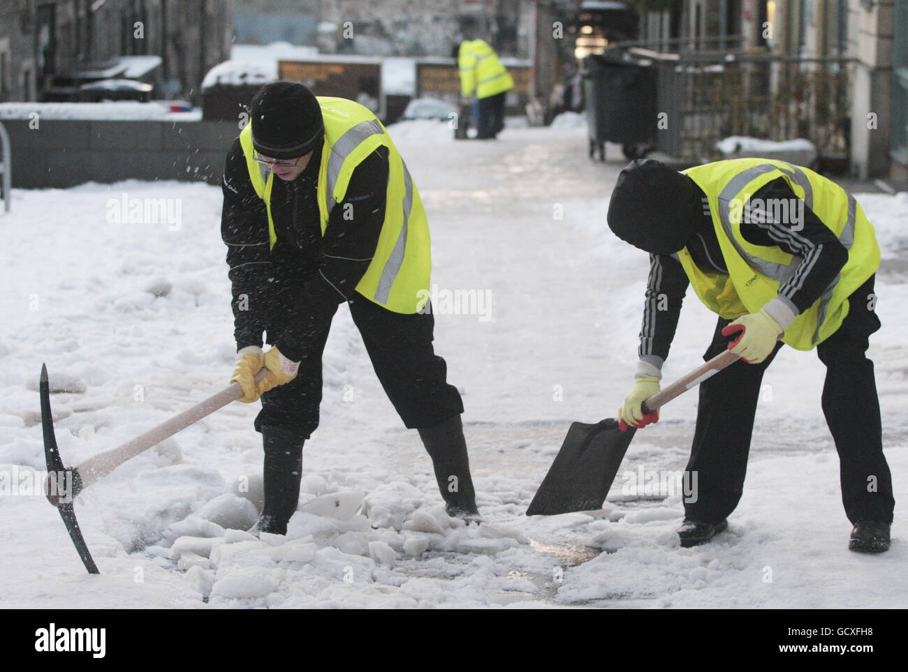 Council workers work to try to clear snow on the Royal Mile in ...
