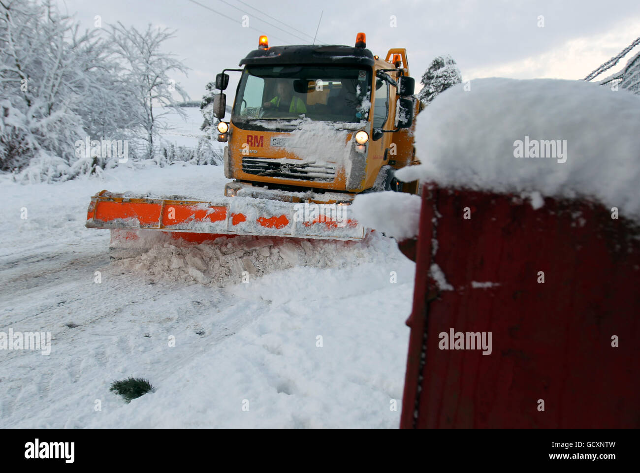 A snow plough clears snow off the road near Denny, central Scotland ...