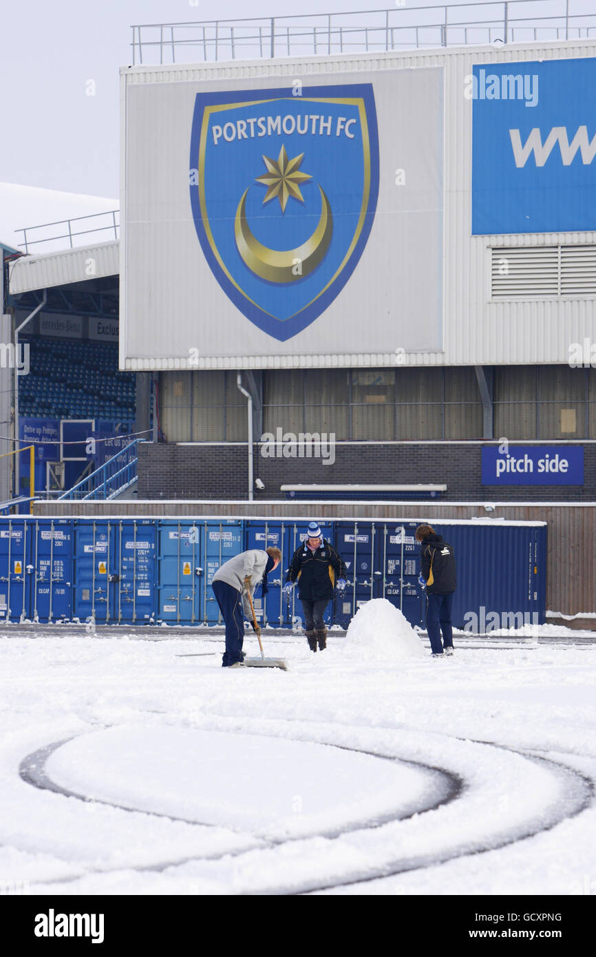 Staff clear snow in the car park outside Portsmouth FC's ground ...