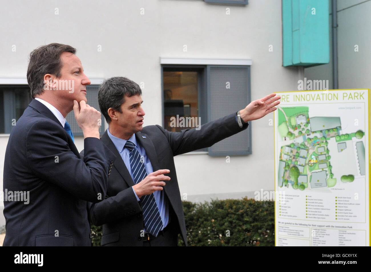 Prime Minister David Cameron speaks with CEO Peter Bonfield (left ...