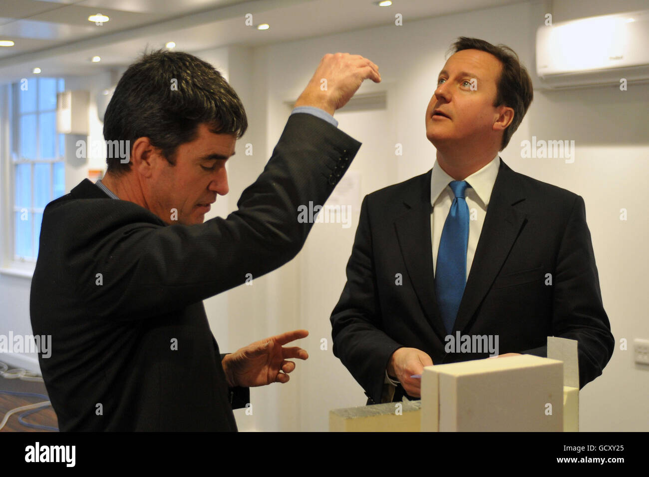 Prime Minister David Cameron speaks with CEO Peter Bonfield during a ...