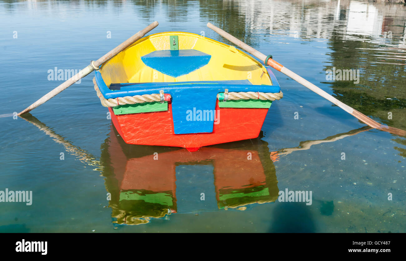 Brightly painted primary colors dinghy reflected in water Stock Photo ...