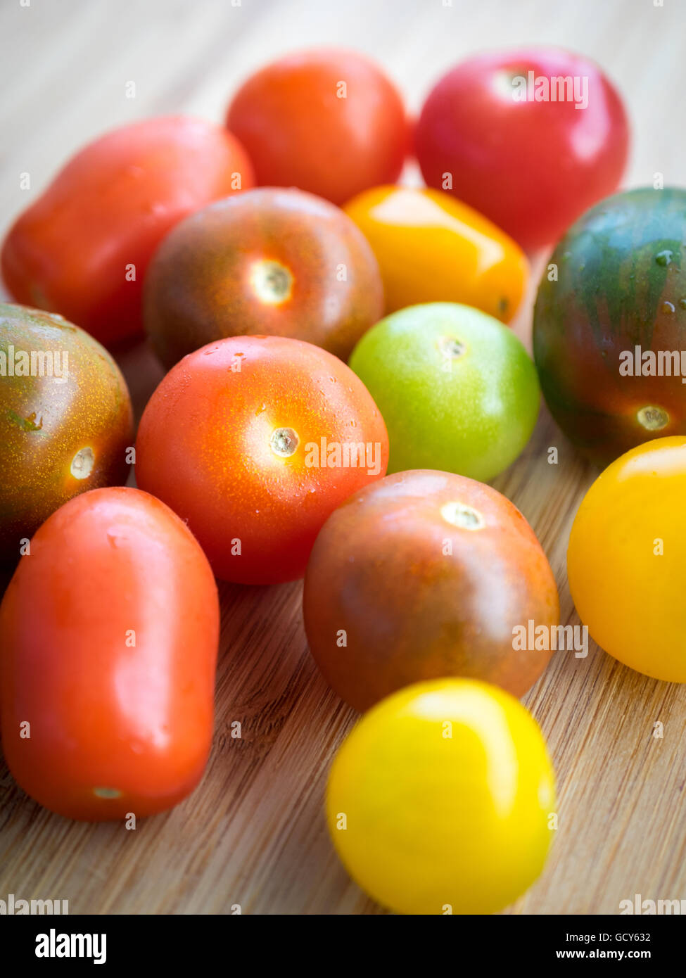 A beautiful, colourful array of summer tomato varieties on a bamboo ...