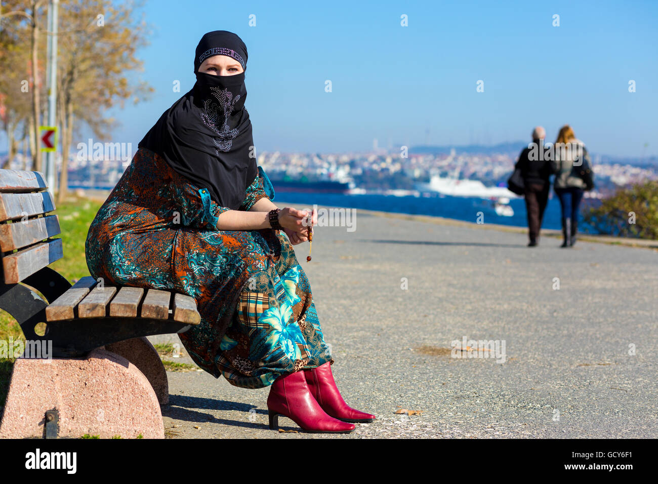 Muslim Style dressed Lady sitting on wooden Bench Stock Photo - Alamy