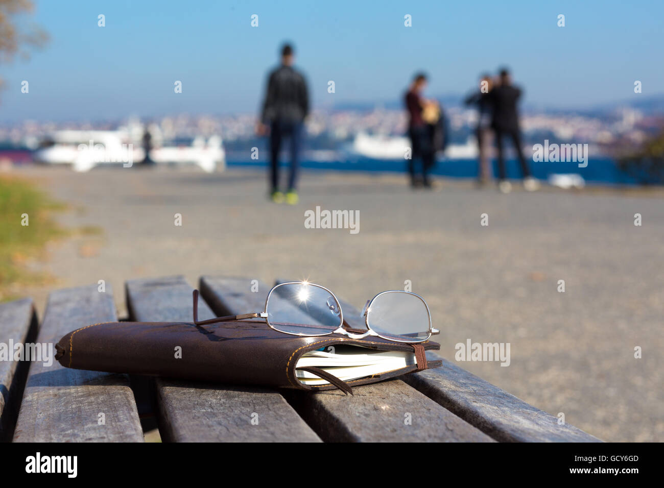 Creative composition with leather Notepad and Glasses on wood bench ...