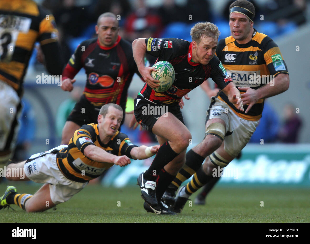 Dragons Tom Riley gets away from Wasps Dave Walder during the Heineken ...