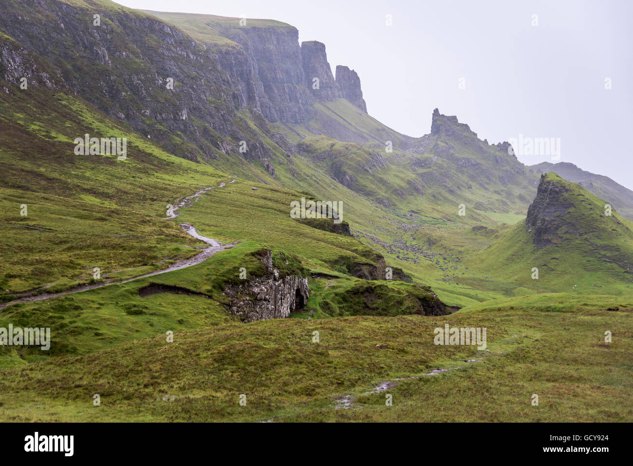 Fog covers the green landscape with cliffs and peaks; Scotland Stock ...
