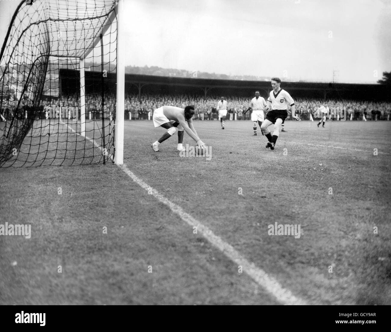 Uganda goalkeeper Nafutali grabs the ball on the ground in front of ...