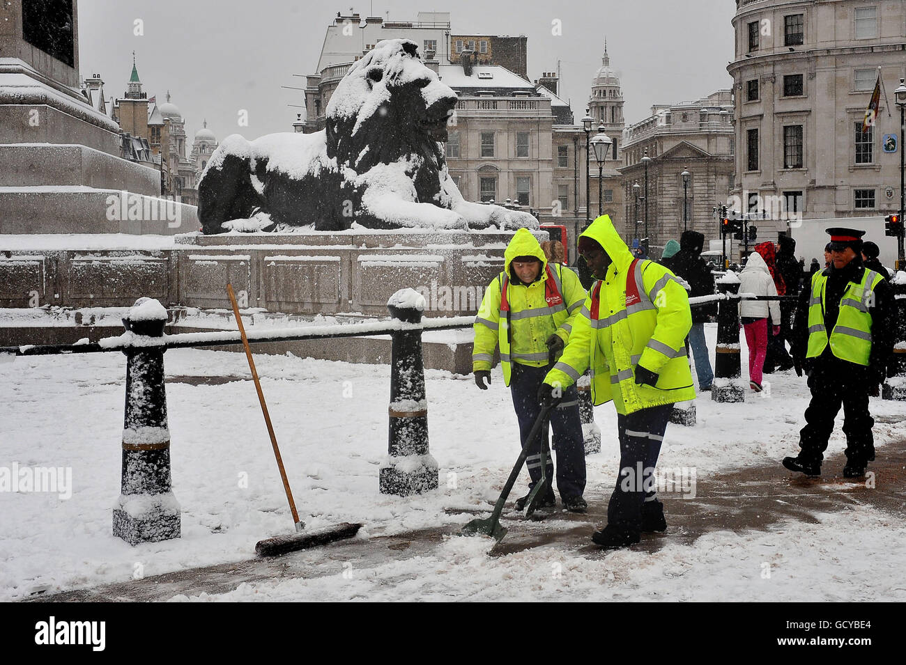 Workmen clear snow in London's Trafalgar Square as winter weather ...