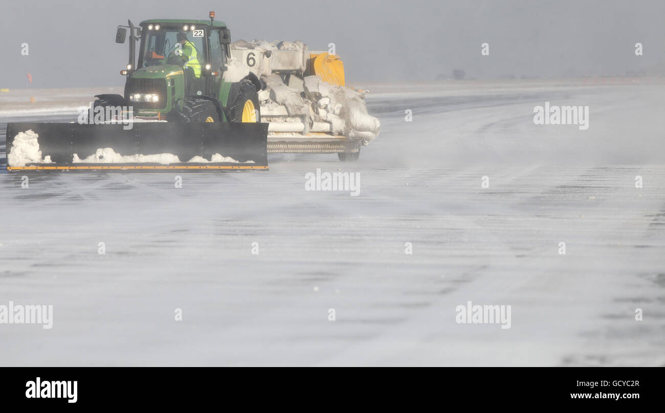 Workmen in snow ploughs remove the snow from Manchester Airport's ...