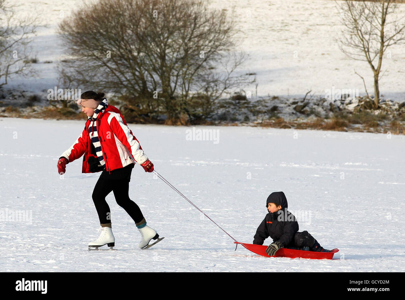 A person pulls a sledge as they skate on a frozen Lake of Menteith on ...
