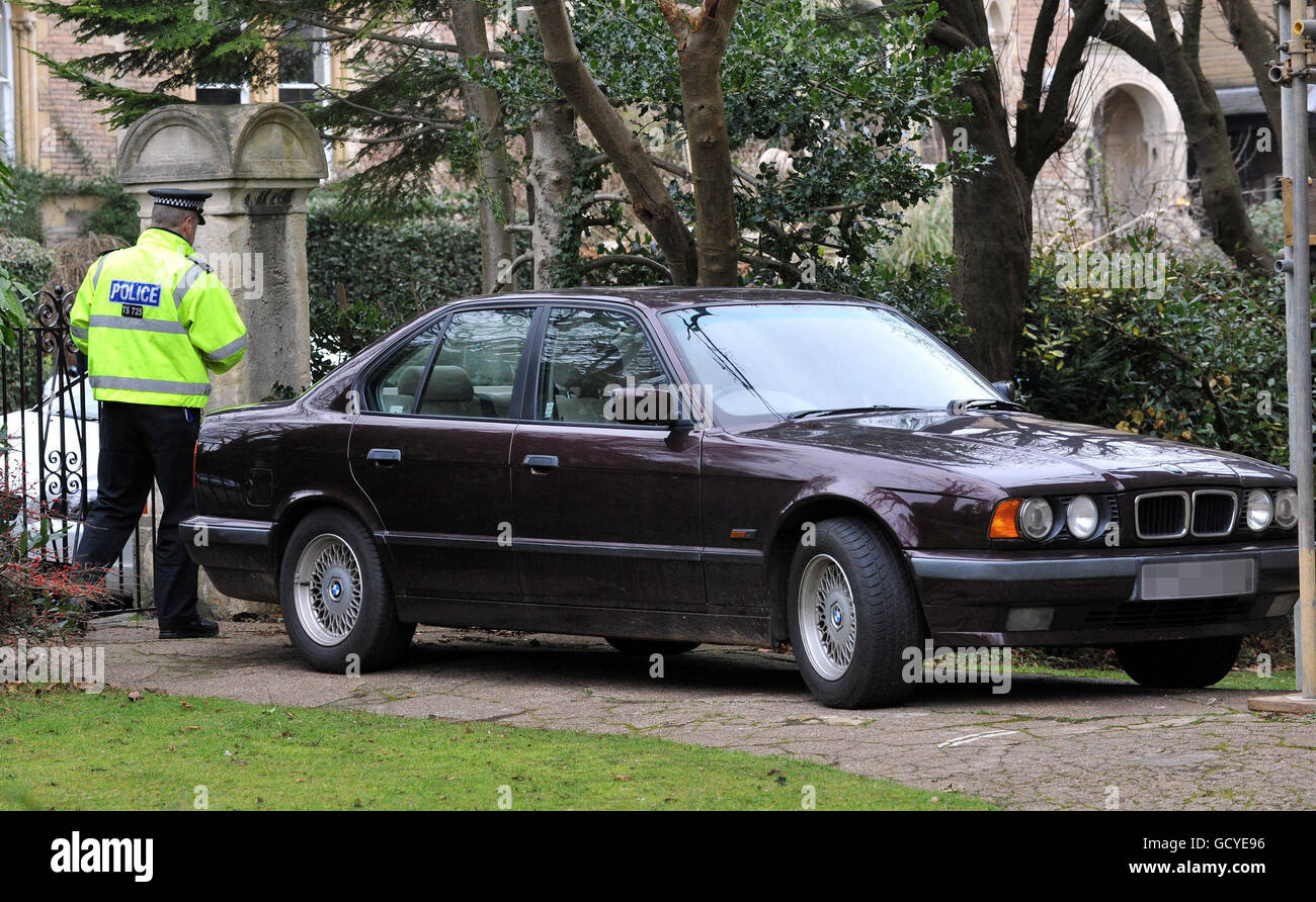 A police officer stands next to a car outside the property of Peter ...