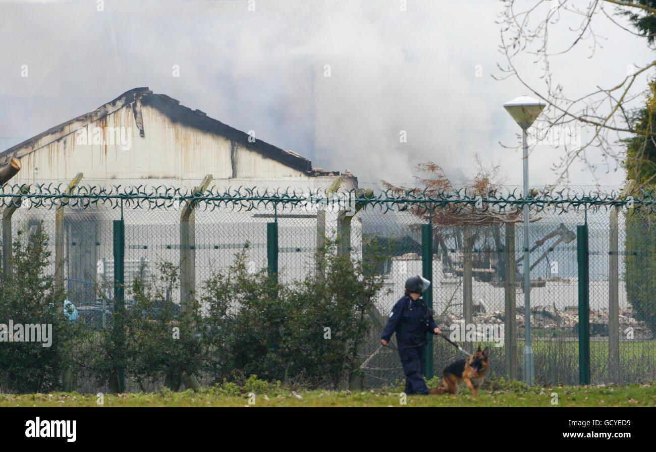 A specialist prison office dog handler patrols outside the perimeter ...