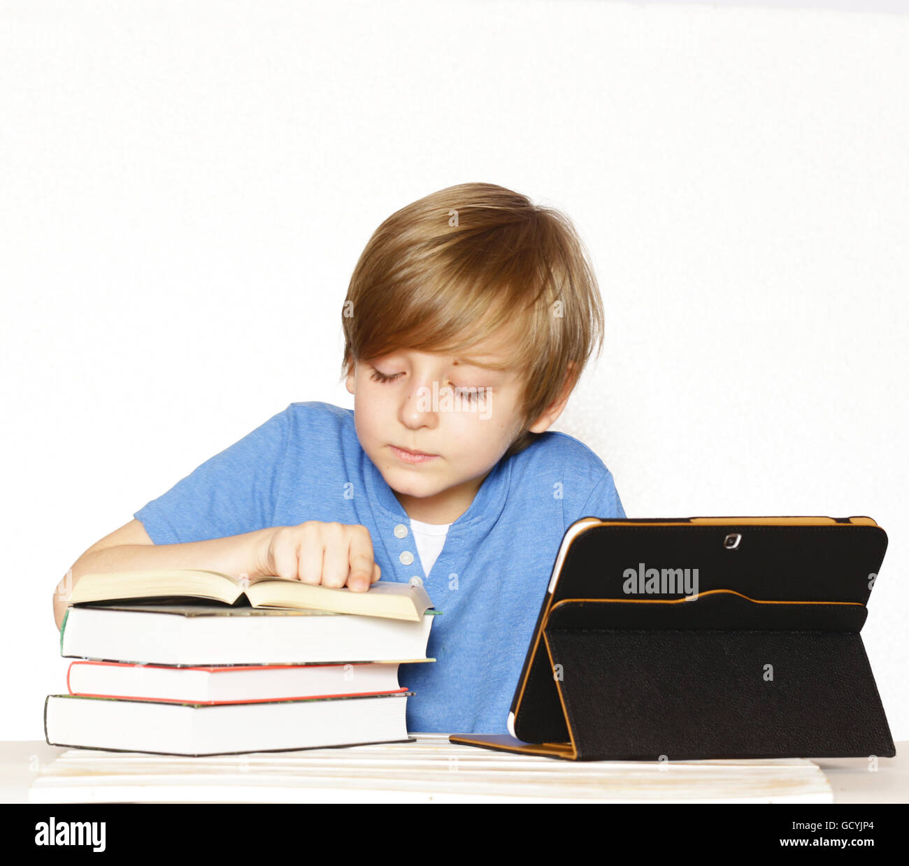 cute young boy with books and electronic tablet Stock Photo - Alamy