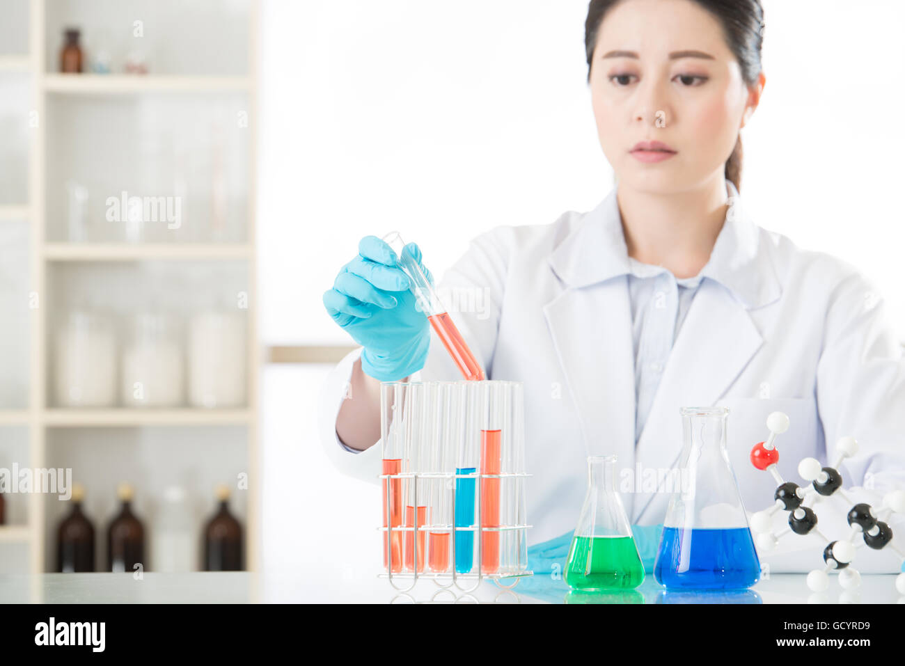 Asian female forensic scientist working on chemicals in laboratory ...