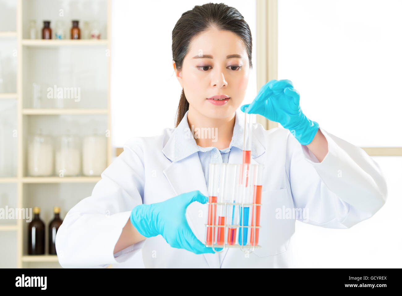 Asian female scientist researcher observing indicator color shift in ...