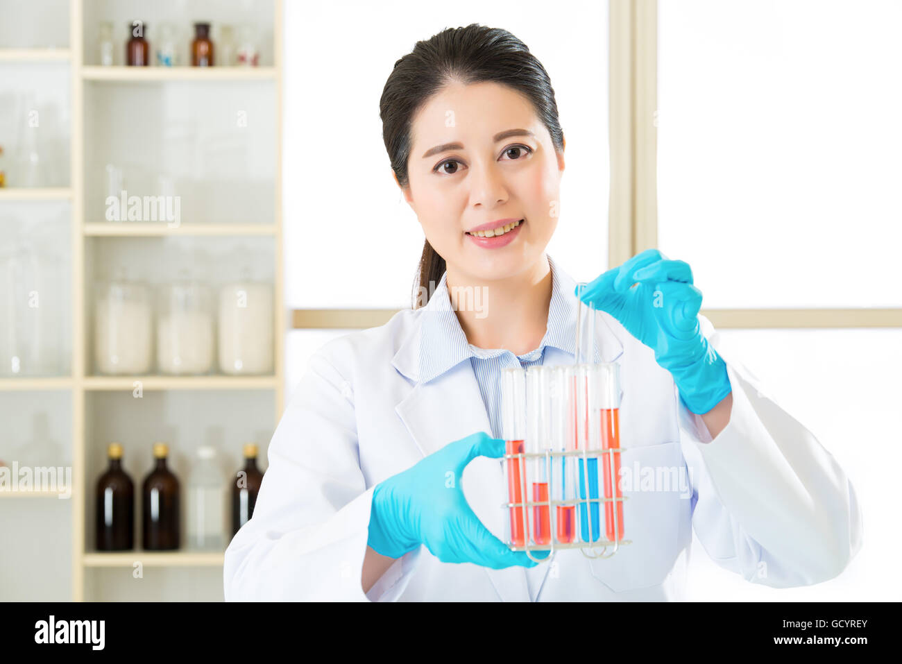 Asian female scientist researcher observing indicator color shift in ...