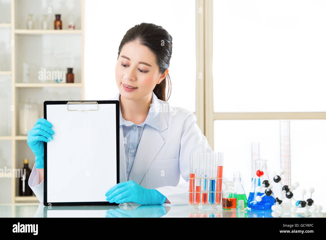 look at science research result on clipboard and show in laboratory ...