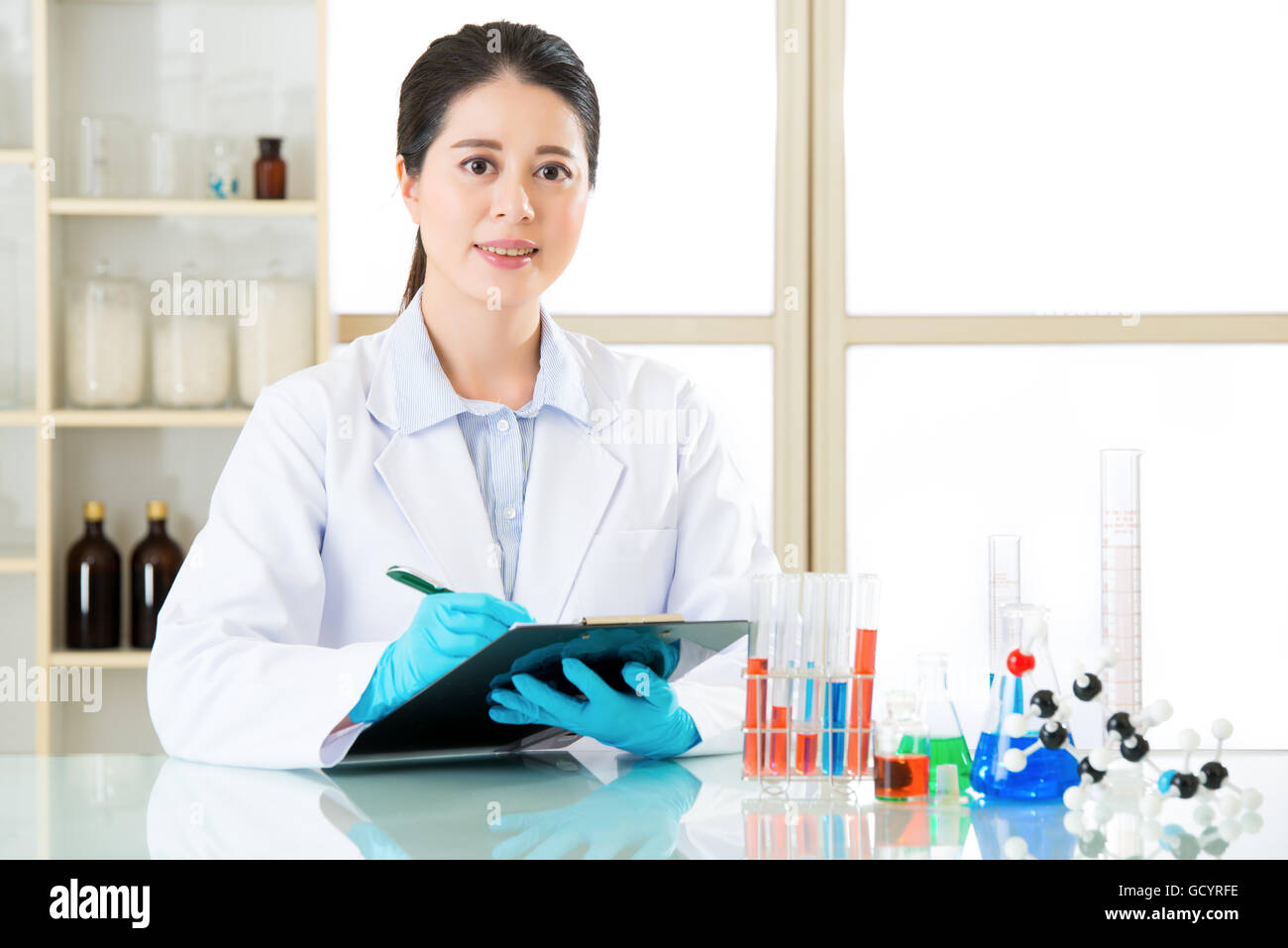 smile female scientist recording her research data write on clipboard ...