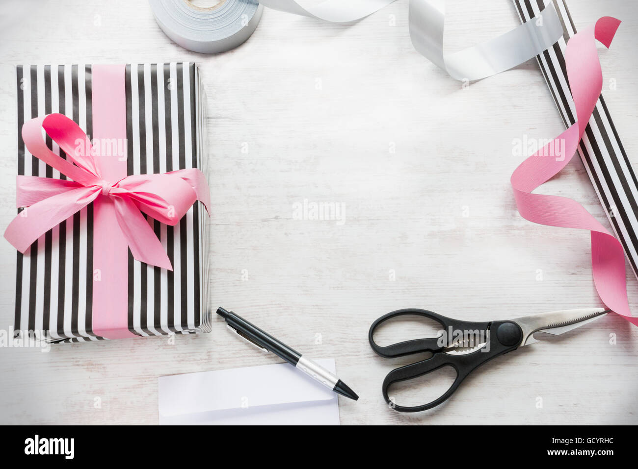 Gift box wrapped in black and white striped paper with pink ribbon and ...