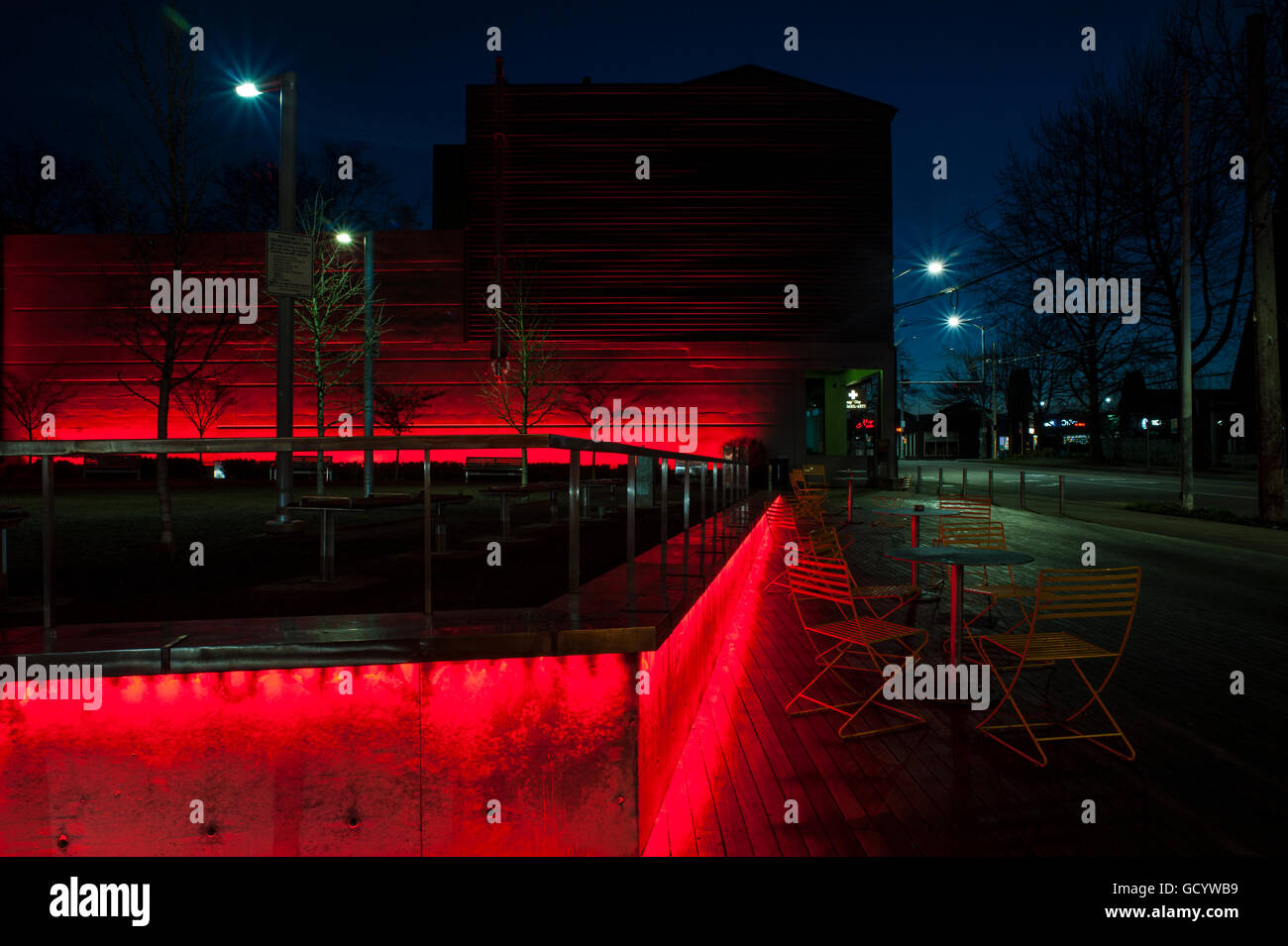 Downtown Seattle park at night with bright red colors and tables and ...