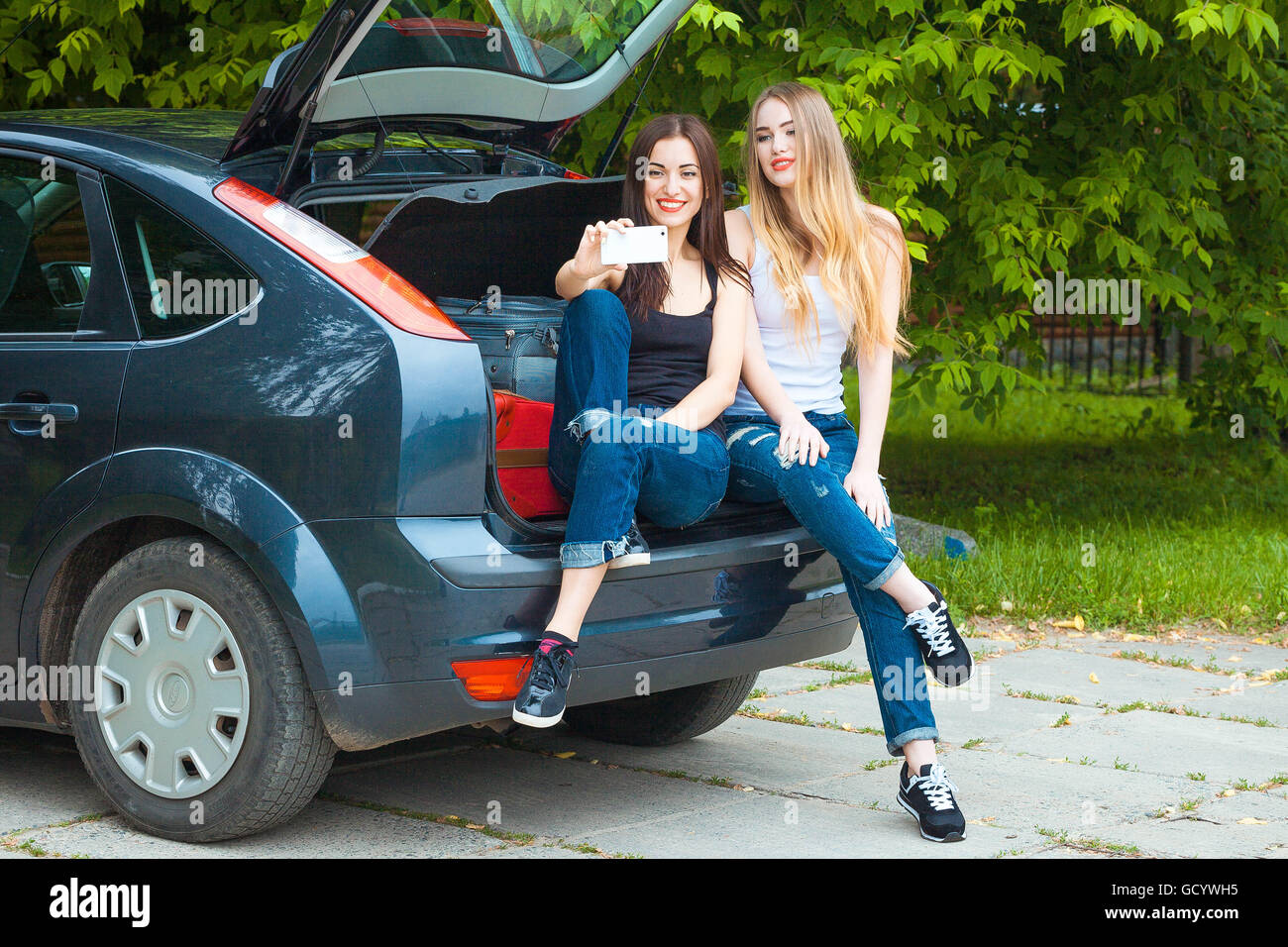 Two girls posing in car Stock Photo - Alamy