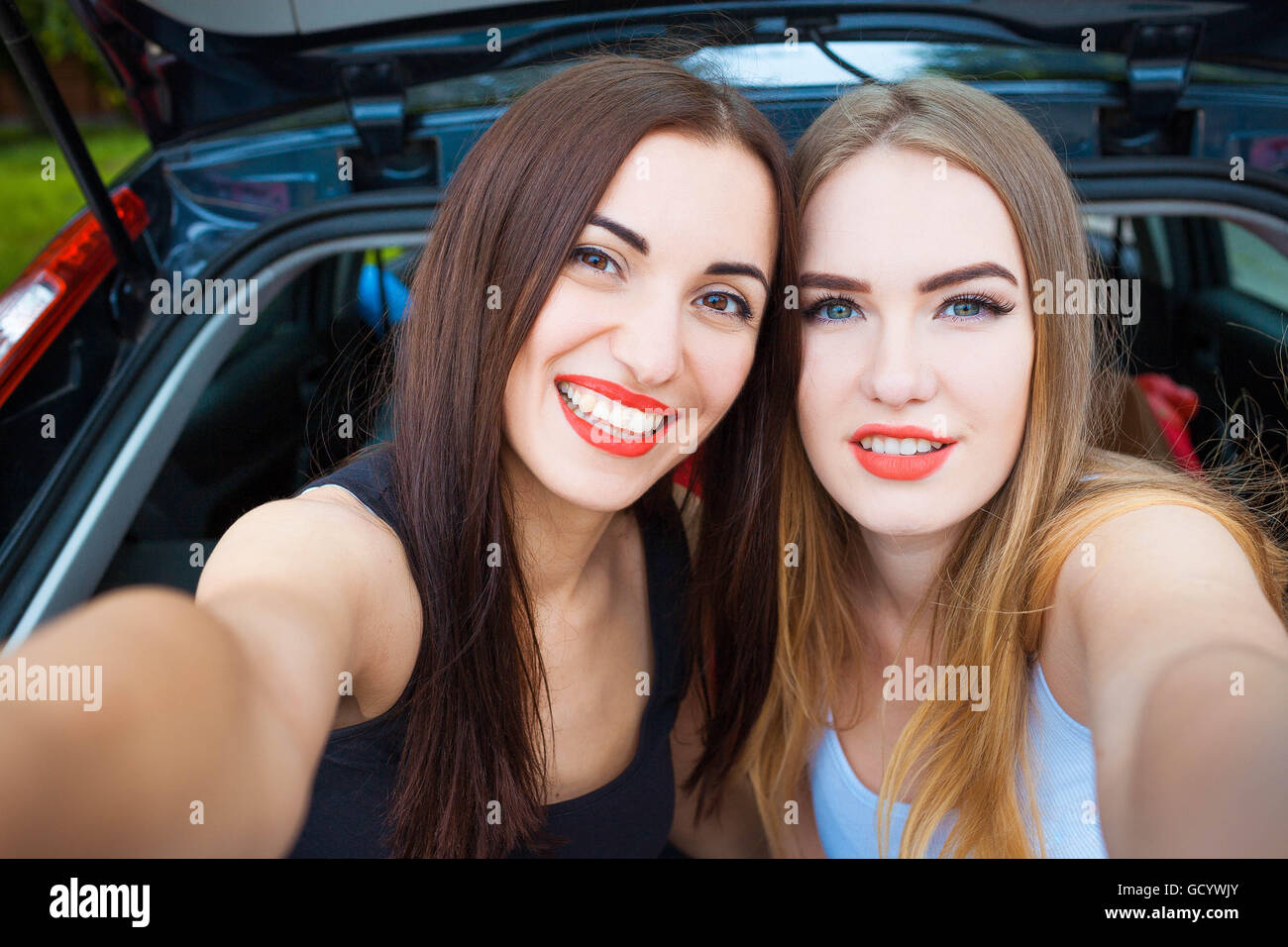 Two girls posing in car Stock Photo - Alamy
