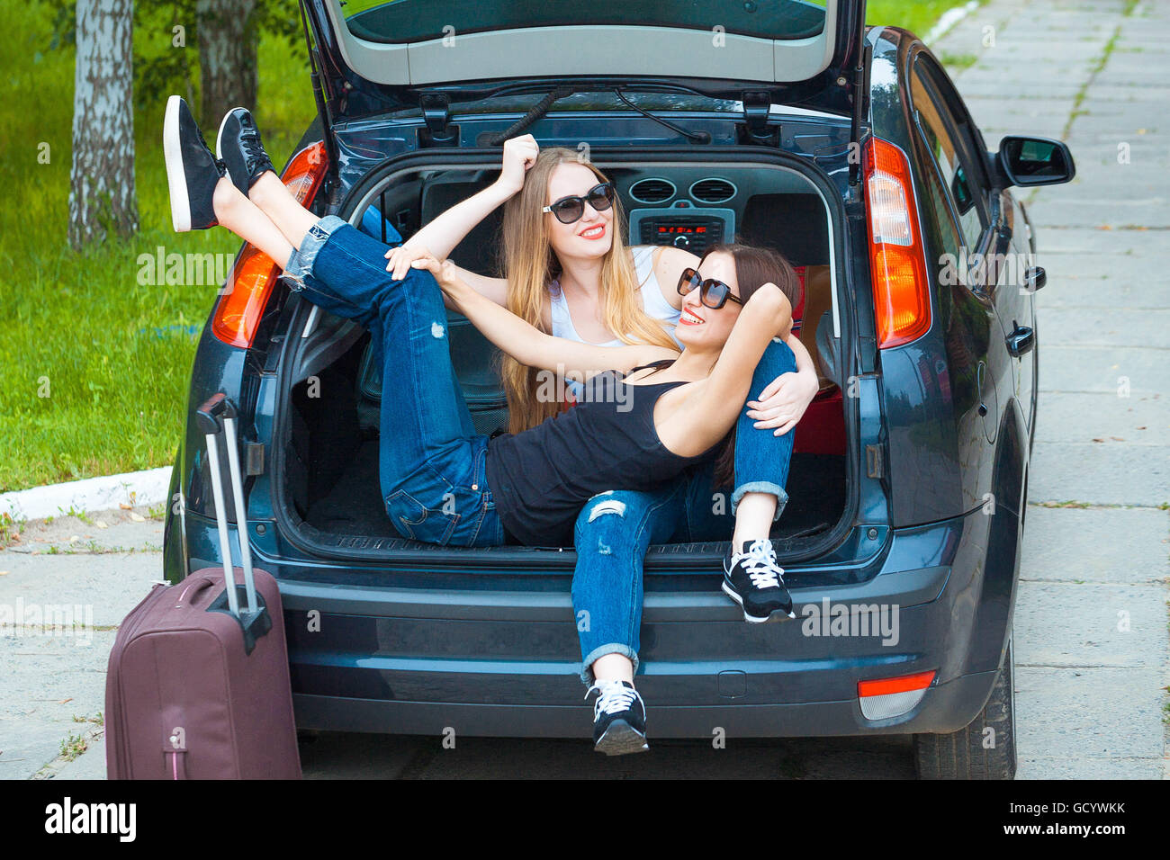 Two girls posing in car Stock Photo - Alamy