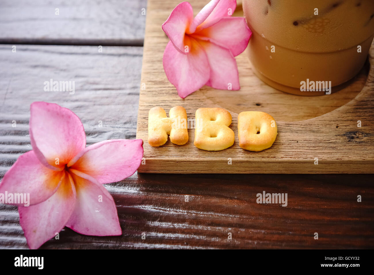 iced coffee and biscuit alphabet spell HBD with rice field background ...