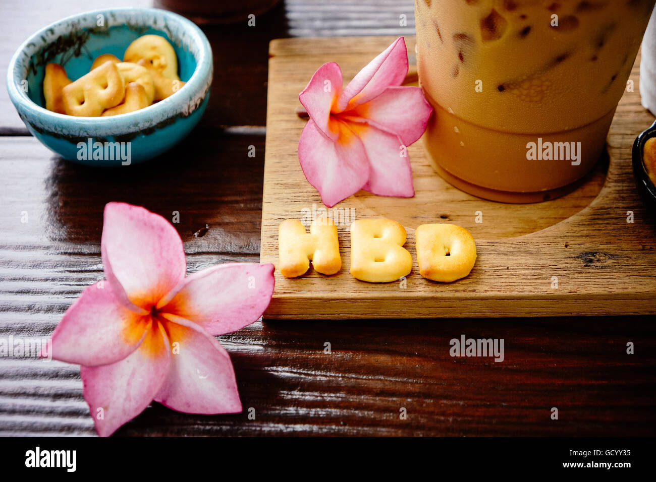 iced coffee and biscuit alphabet spell HBD with rice field background ...