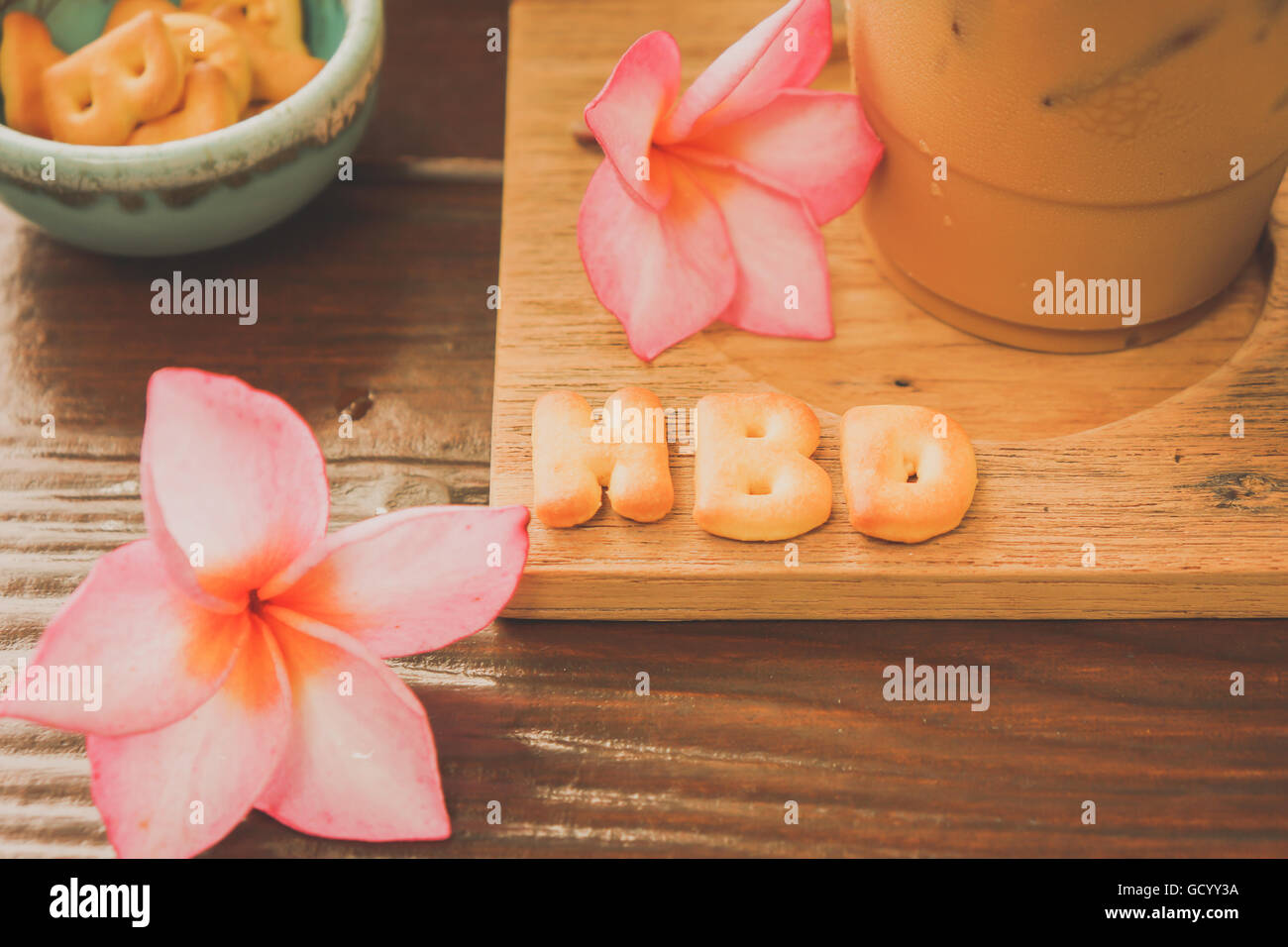 iced coffee and biscuit alphabet spell HBD with rice field background ...
