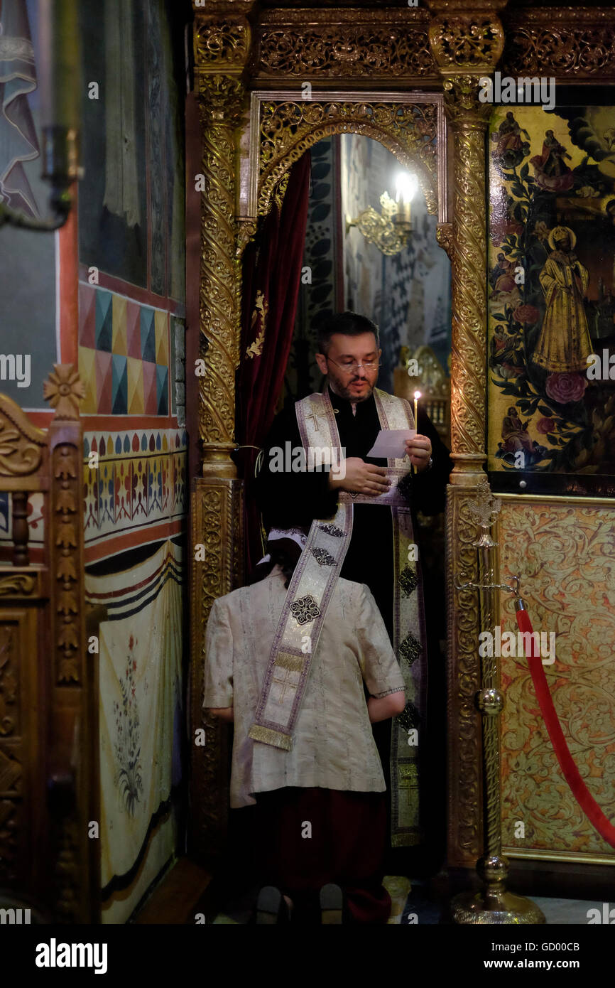 A Romanian Orthodox priest gives blessings to believers inside Saint ...