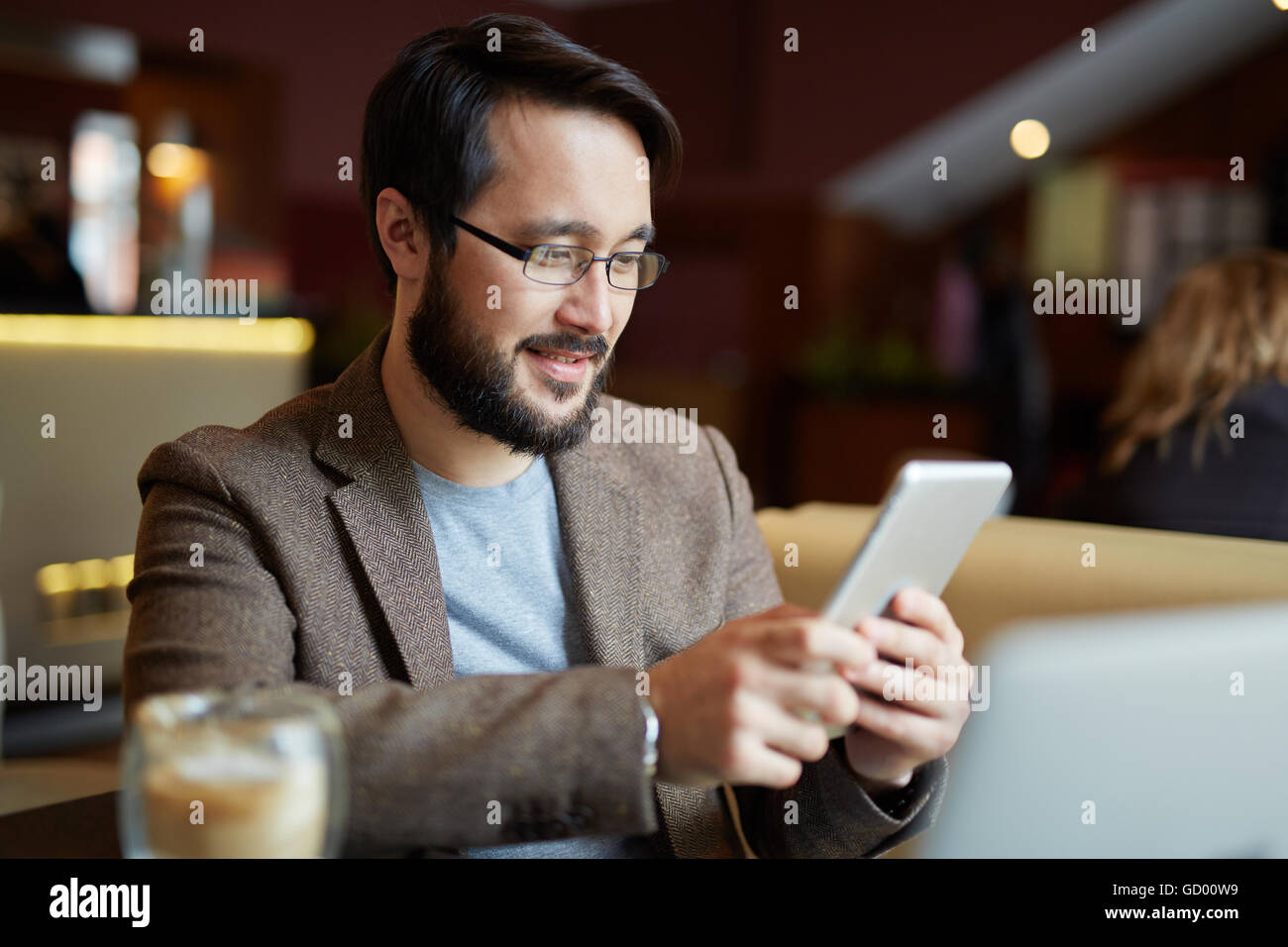 Cheerful bearded businessman using smartphone hi-res stock photography ...