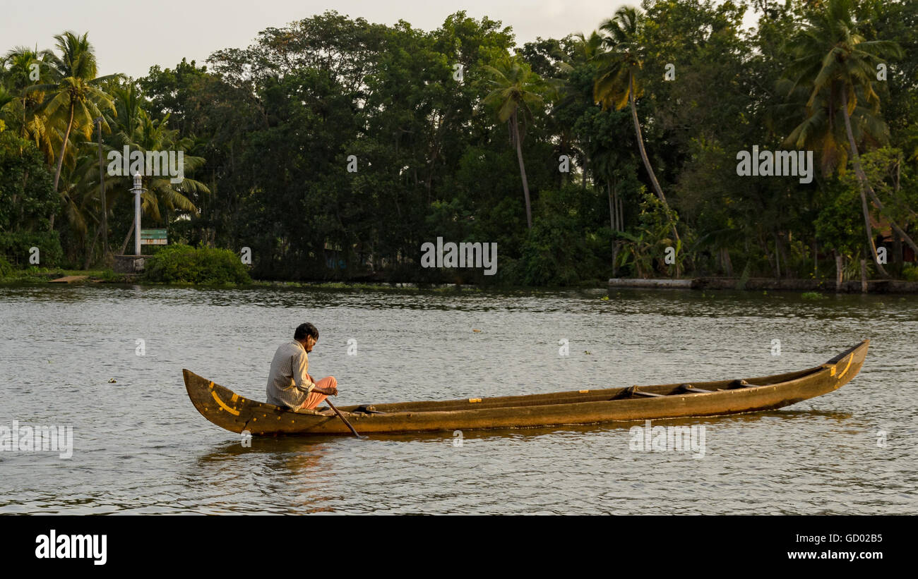 Colour photograph of a man paddling a canoe ferry in Kerela India Stock ...