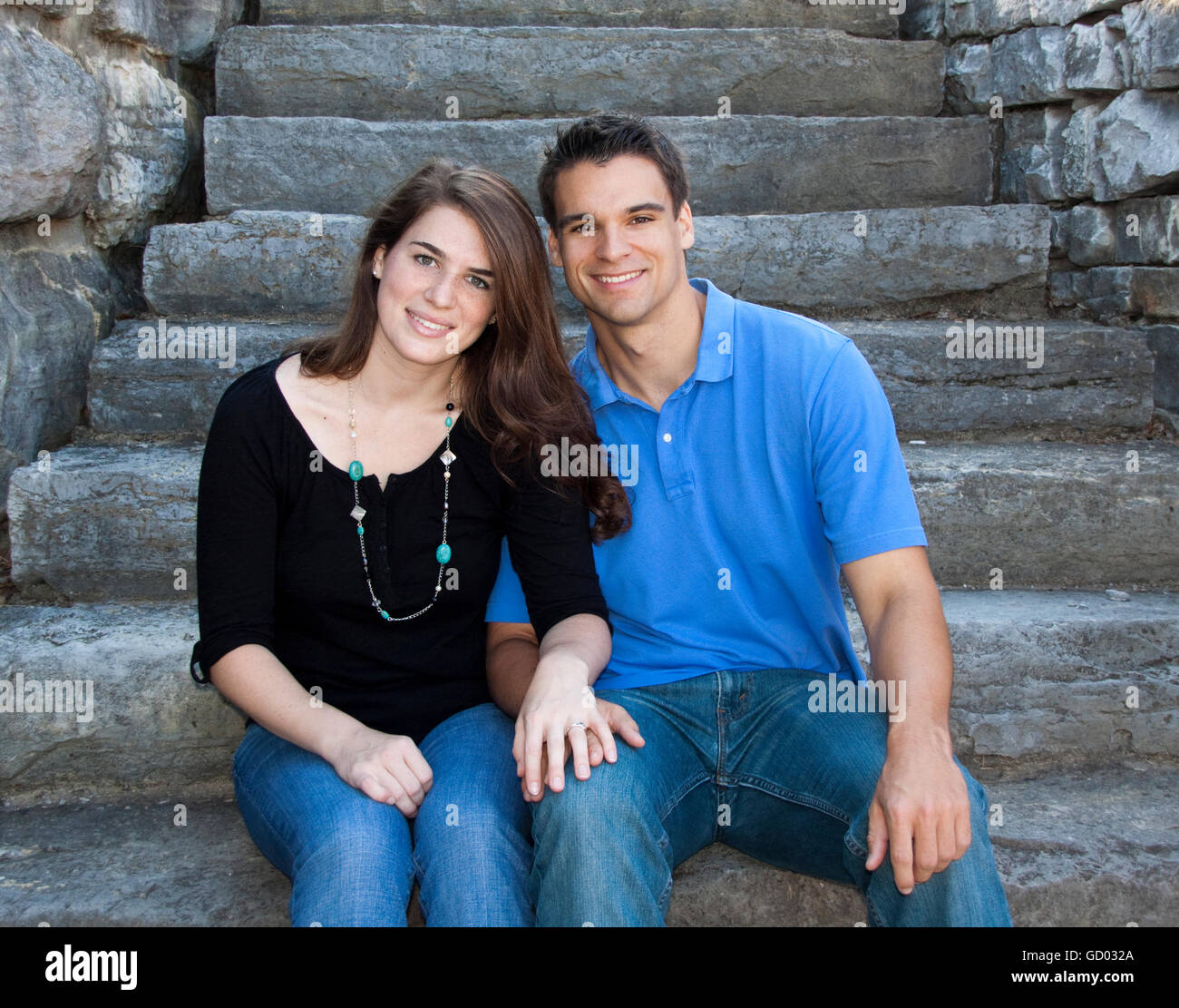Young happy couple posing for portrait on steps Stock Photo - Alamy