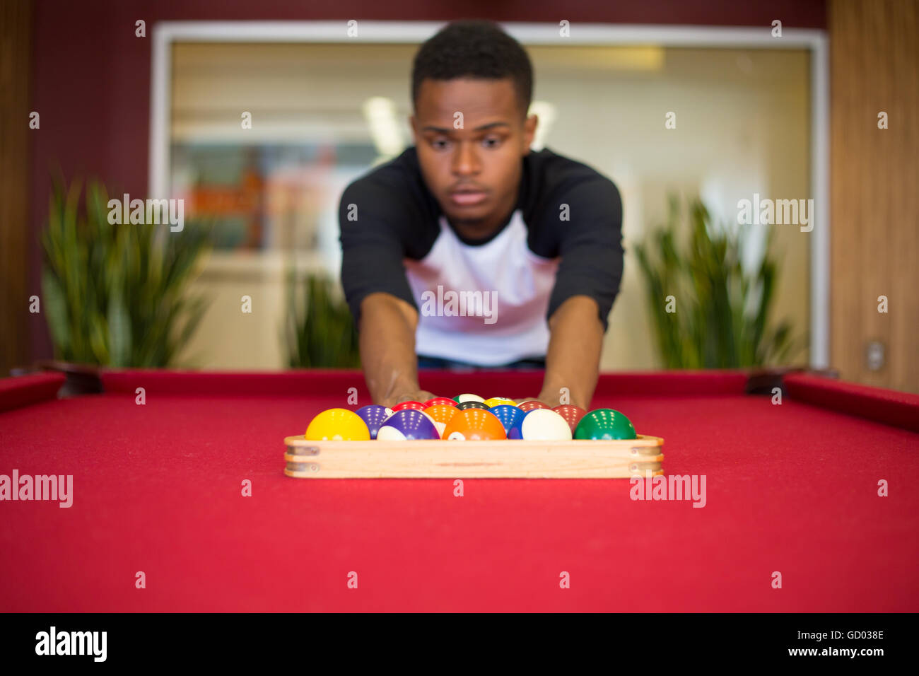 Closeup portrait, young man hanging out, playing billiards at red pool ...