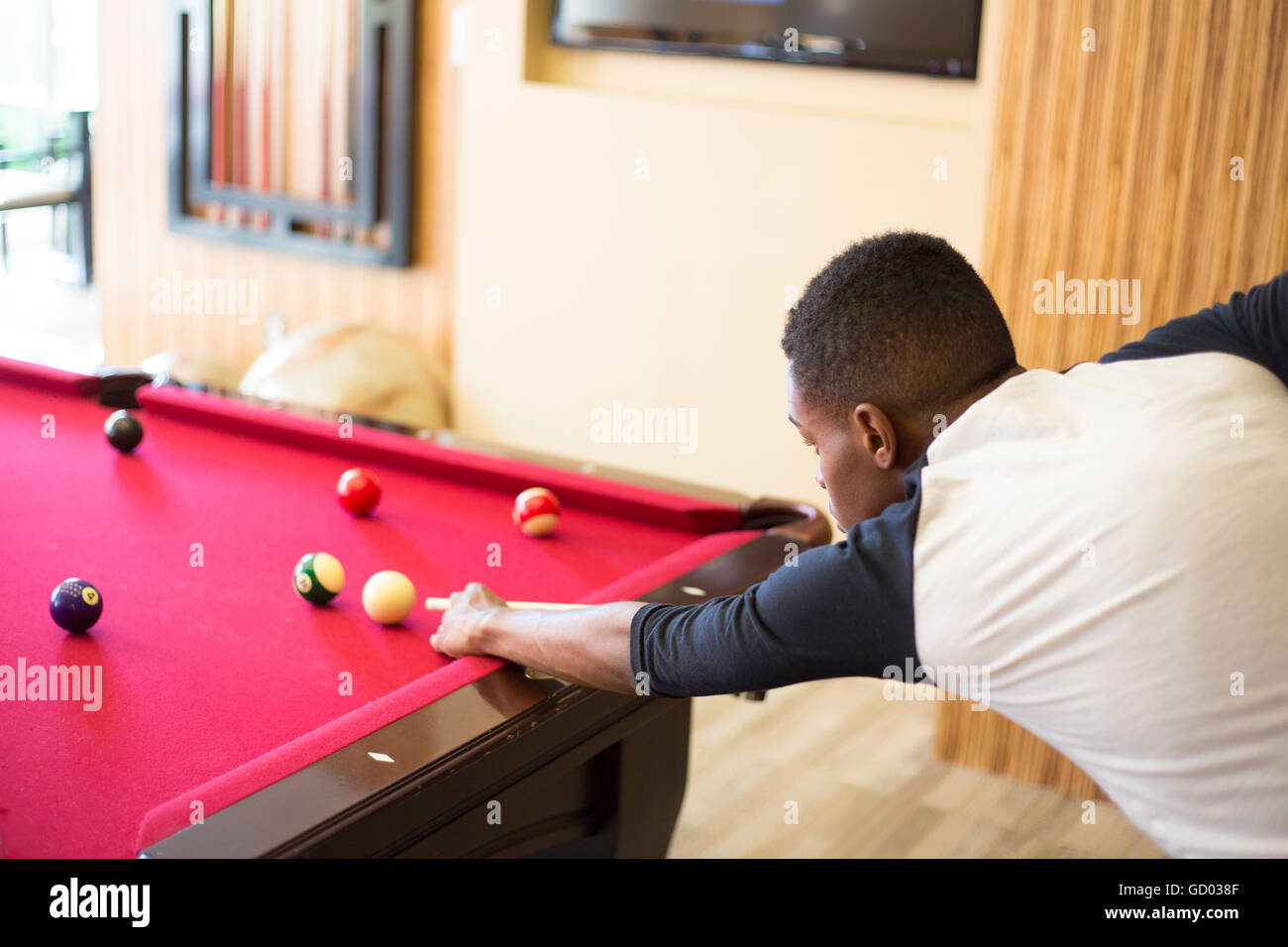 Closeup portrait, young man hanging out, playing billiards at red pool ...