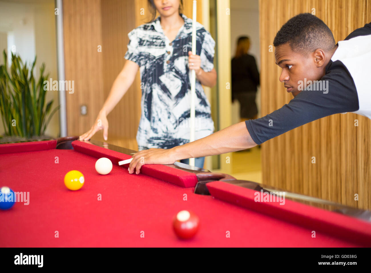 Closeup portrait, young man hanging out, playing billiards at red pool ...