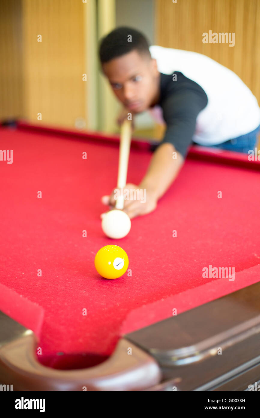 Closeup portrait, young man hanging out, playing billiards at red pool ...