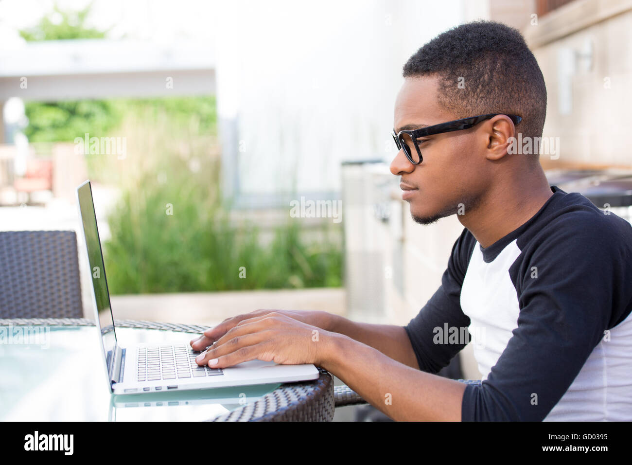Closeup portrait, young nerdy man in big black glasses surfing the web ...