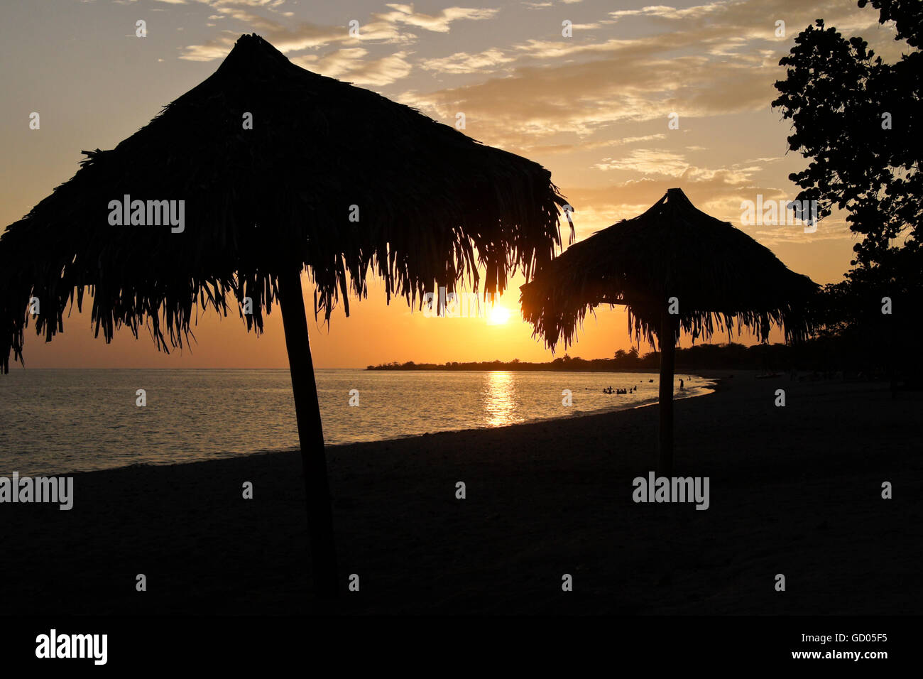 Palapas frame sunset at Playa Ancon, Trinidad, Cuba Stock Photo - Alamy