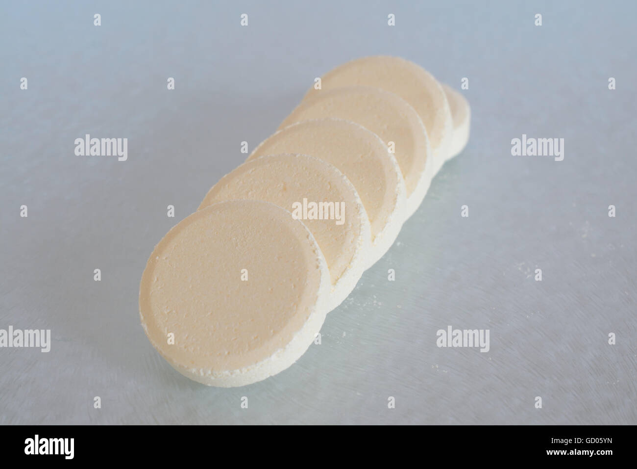 Soluble tablets in a row on glass table top closeup Stock Photo - Alamy