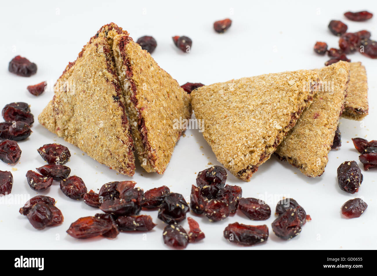 Integral triangle cookies with red raisins on white table Stock Photo ...