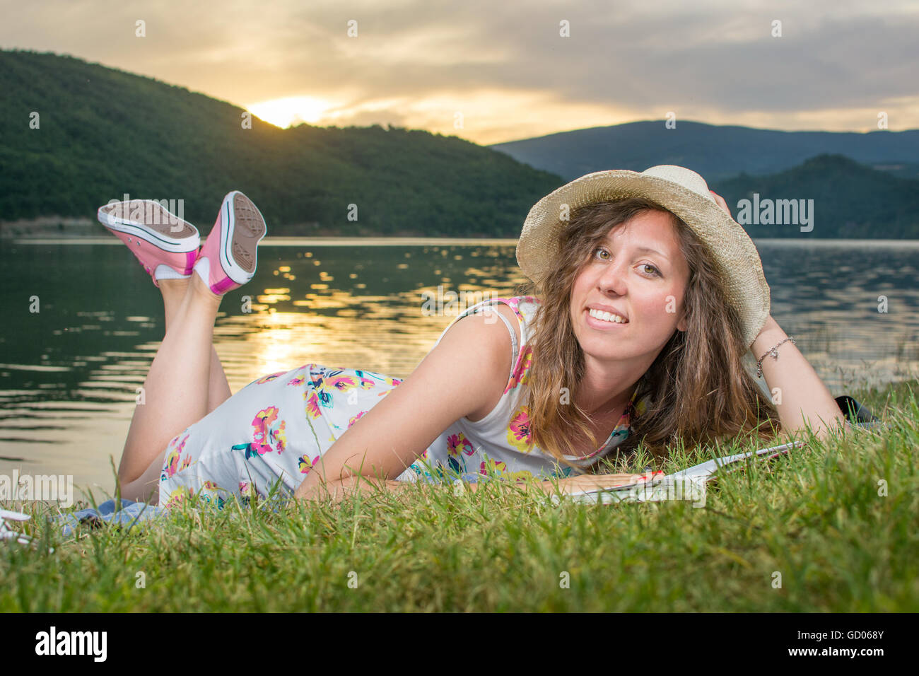 Young woman reading a book by the lake. Solo relaxation Stock Photo - Alamy