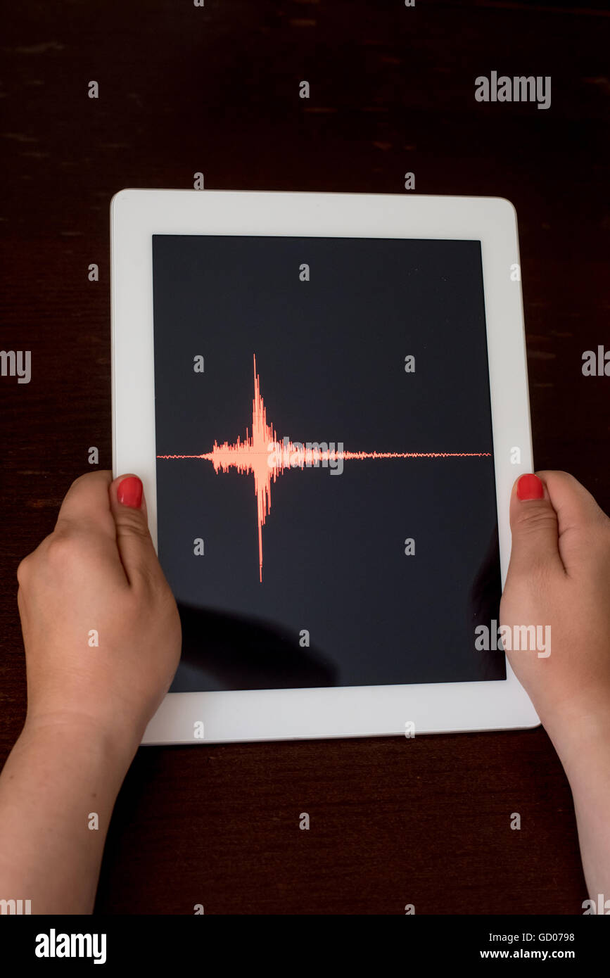 Woman hand pointing a red earthquake with a black background on a white ...