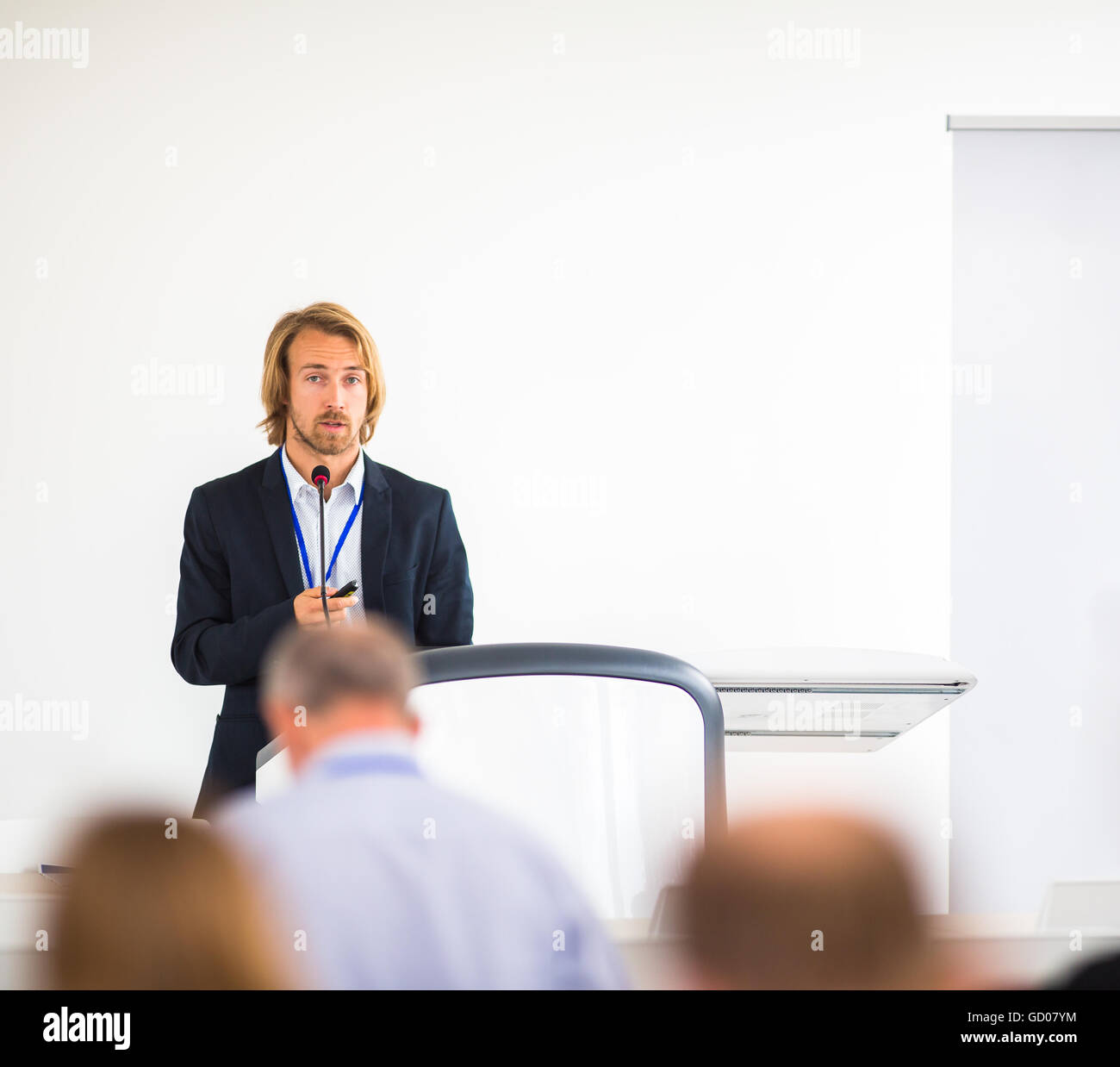 Handsome young man giving a speech at a conference Stock Photo - Alamy