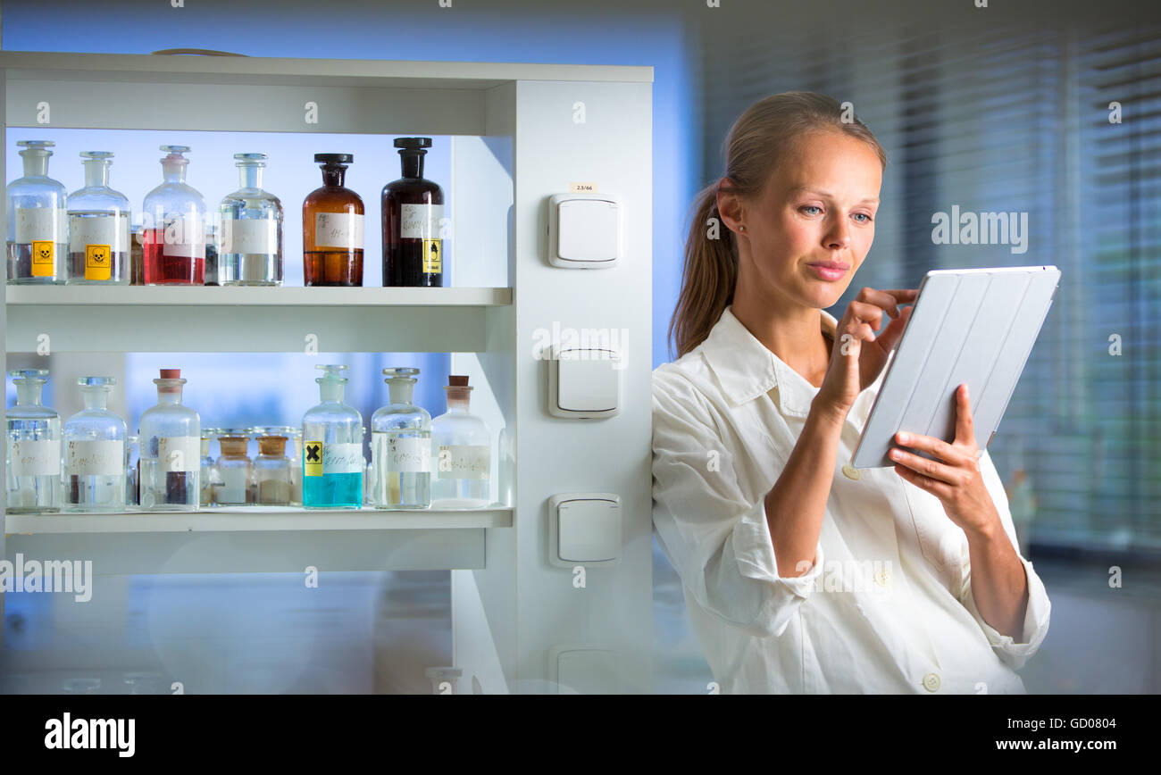 Portrait of a female researcher doing research in a lab, using a tablet ...