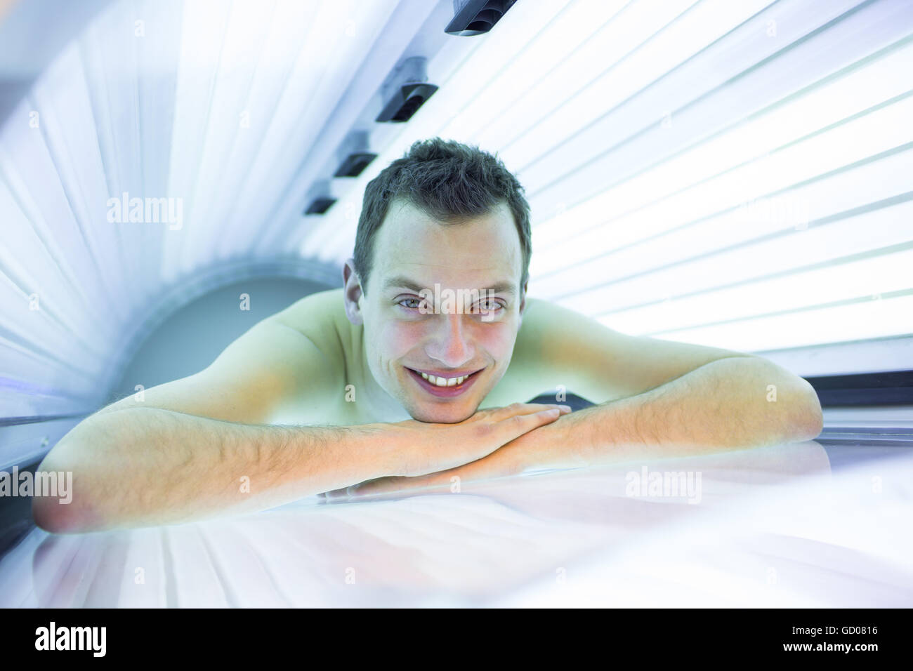 Handsome young man relaxing during a tanning session in a modern ...
