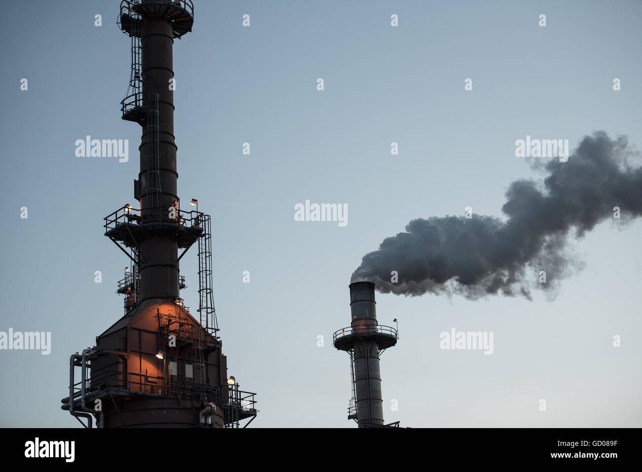 Oil Refinery or Petrochemical plant chimneys at dusk Stock Photo - Alamy