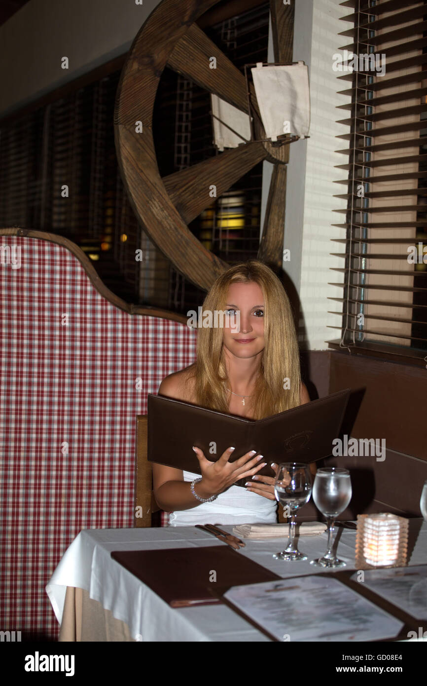 Beautiful young lady alone in restaurant Stock Photo - Alamy